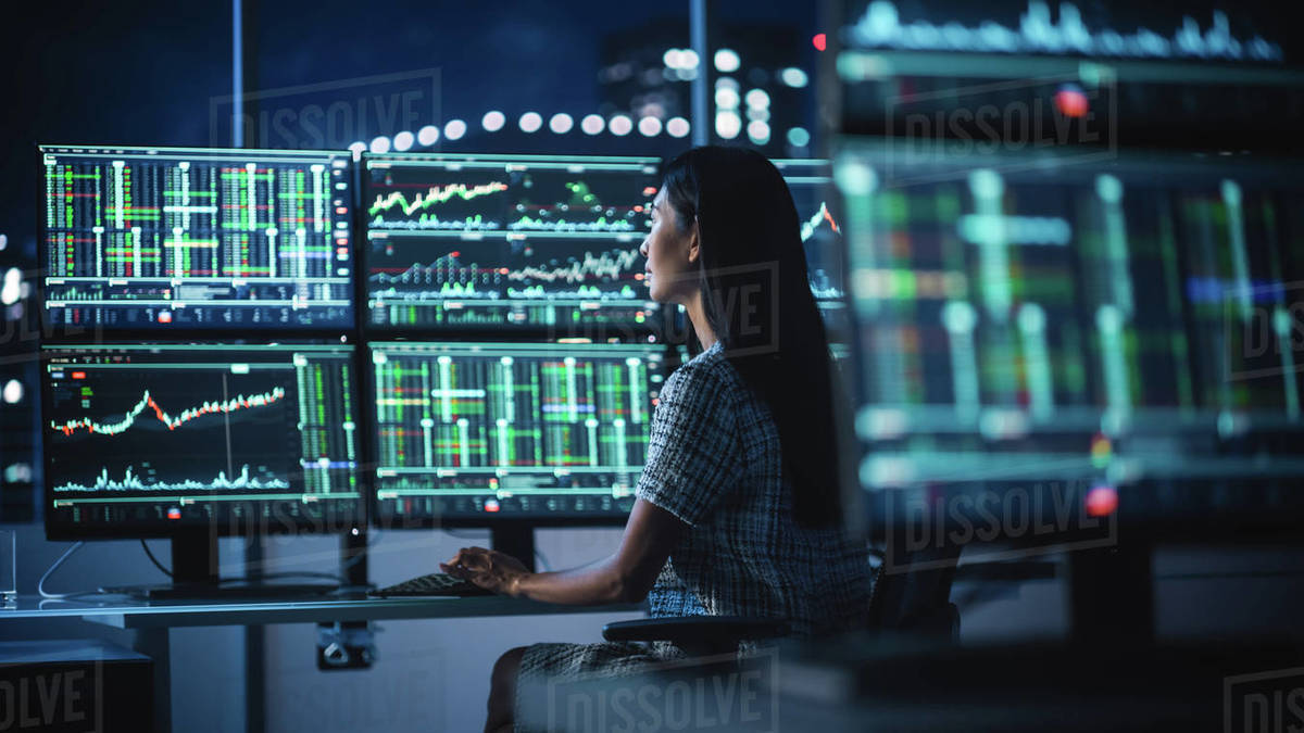 Financial Analyst Working on a Computer with Multi-Monitor Workstation ...