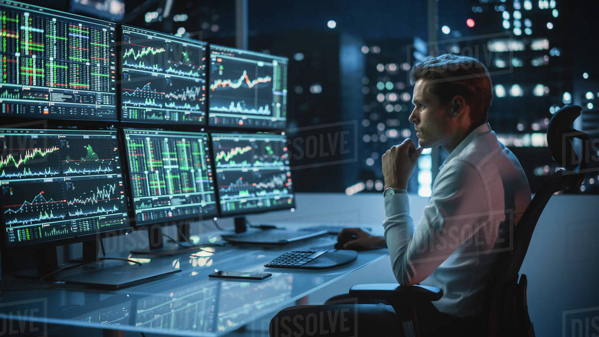 Financial Analyst Working on a Computer with Multi-Monitor Workstation ...