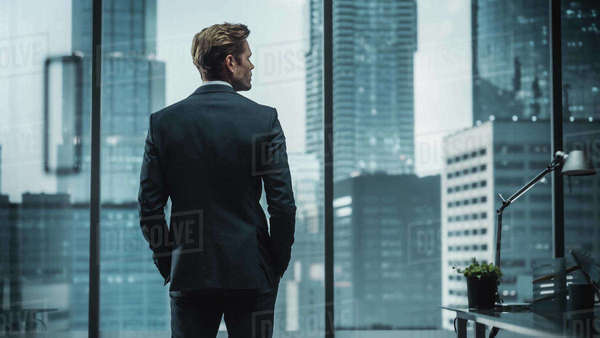 Businessman Standing Next to a Window in a Modern Office - Royalty-free ...