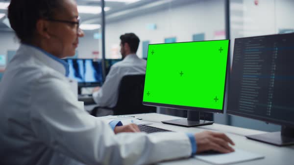 Female Medical Doctor is Working on Computer with Green Screen Mock Up ...