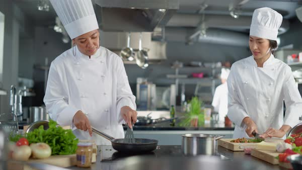 Restaurant Kitchen: Portrait of Asian and Black Female Chefs Preparing ...