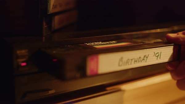 Close Up of a Person Inserting a VHS Cassette in a Player with ...