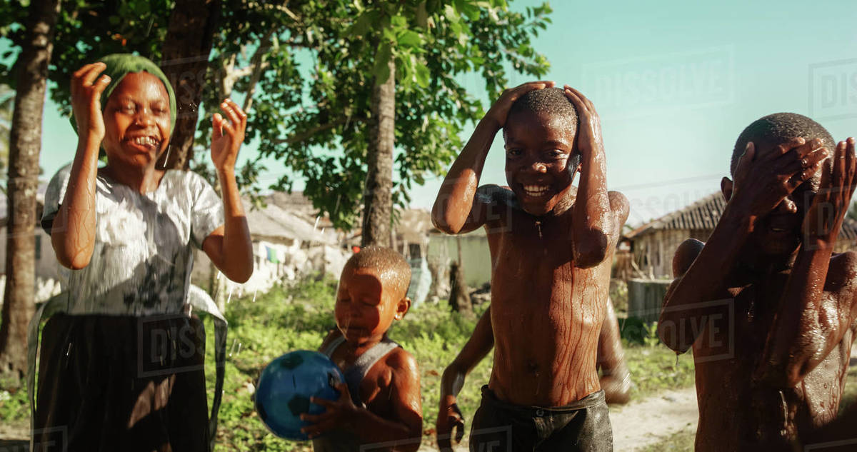 Group of African Kids Jumping and Laughing when Water Gets Poured on ...