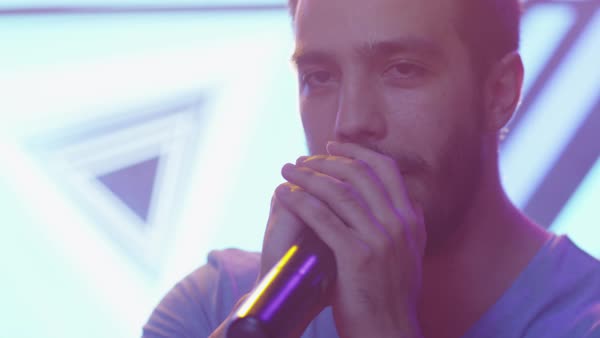 Singer is singing in nightclub, bright animation on background, close ...