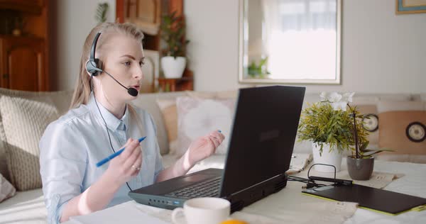 Sales representative in headset speaking to client and making video ...