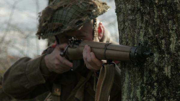 Reenacted close up shot of a British WW2 soldier as he aims his enfield ...