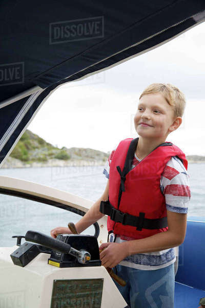 Boy driving motor boat - Royalty-free Stock Photo | Dissolve