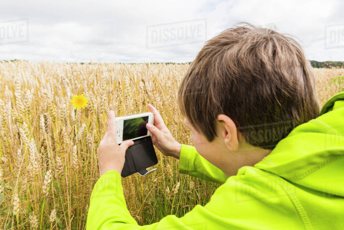 Boy photographing with cell phone - Royalty-free Stock Photo | Dissolve