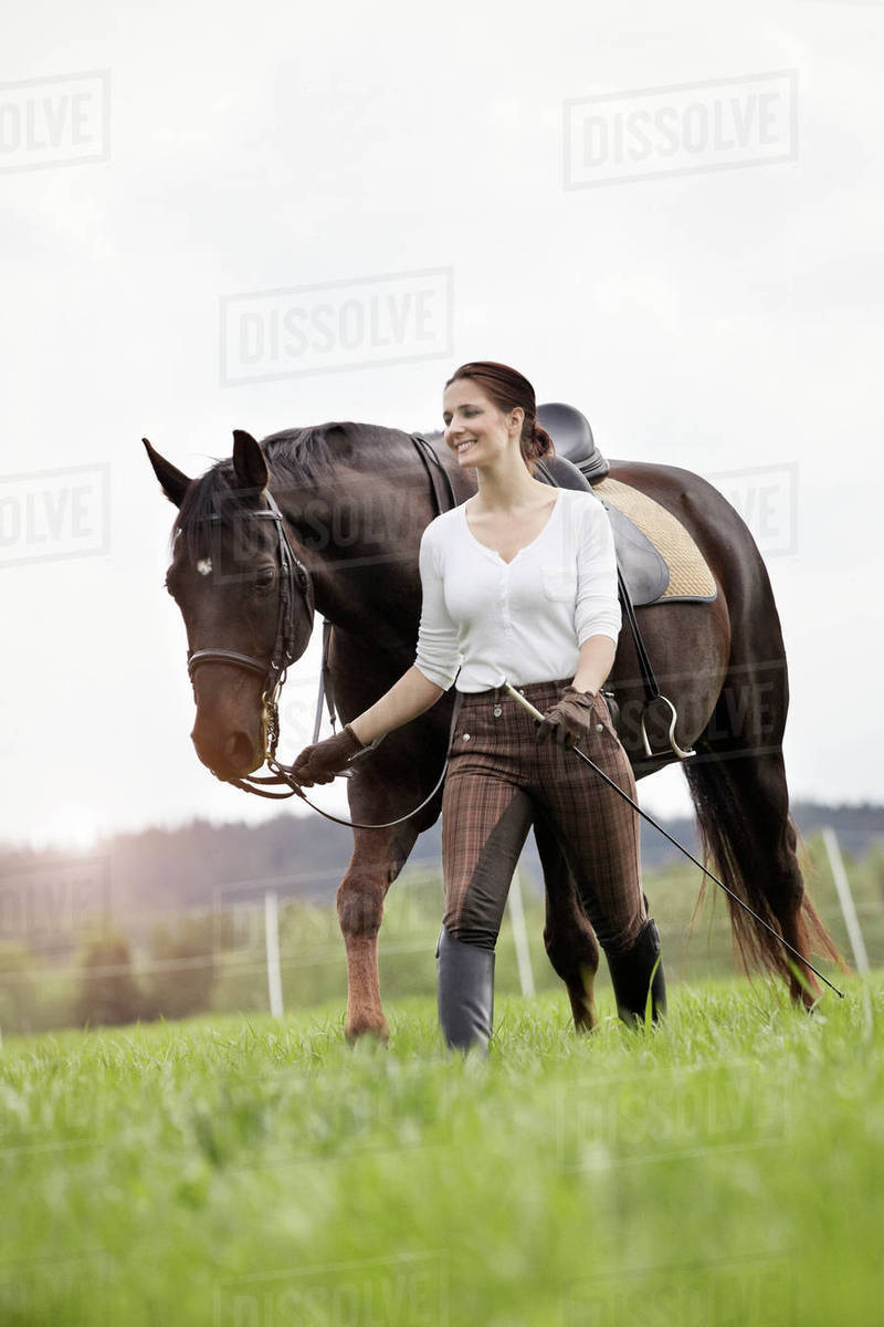 Woman walking with horse - Royalty-free Stock Photo | Dissolve