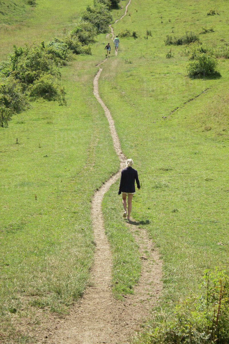 People walking through meadow - Royalty-free Stock Photo | Dissolve