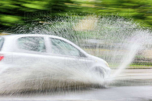 Car splashing water on road - Royalty-free Stock Photo | Dissolve
