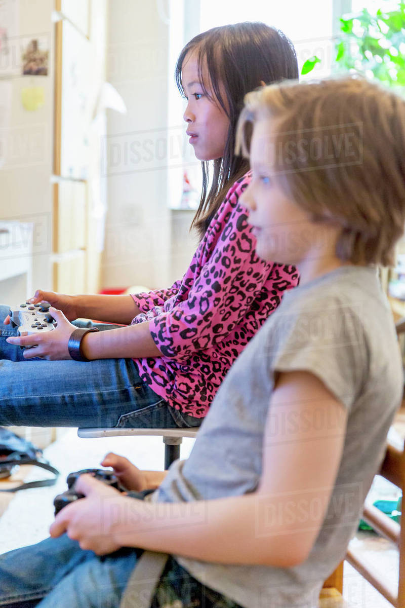 Boy and girl playing video game - Royalty-free Stock Photo | Dissolve