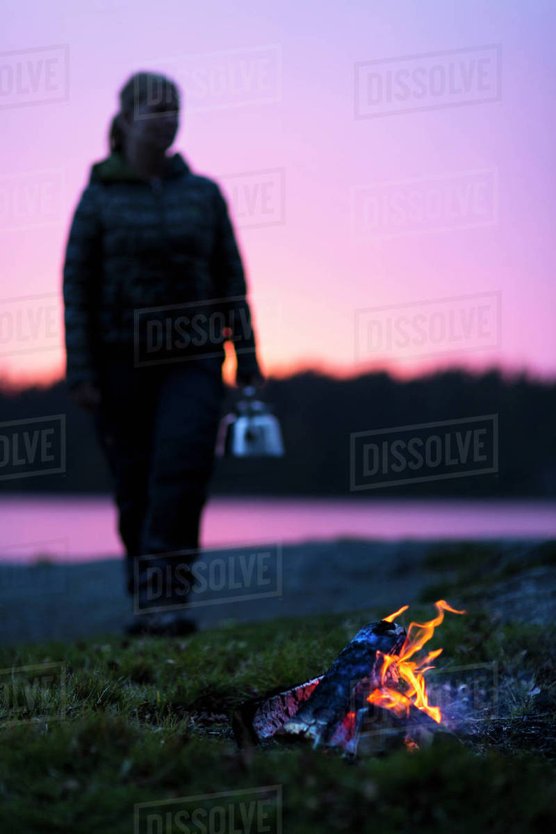 Campfire, woman on background - Royalty-free Stock Photo | Dissolve