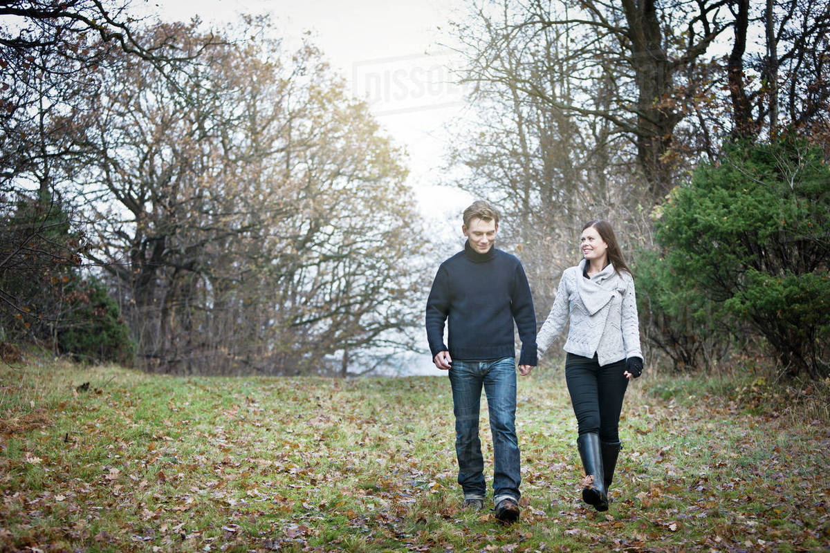 Young couple walking in forest - Royalty-free Stock Photo | Dissolve