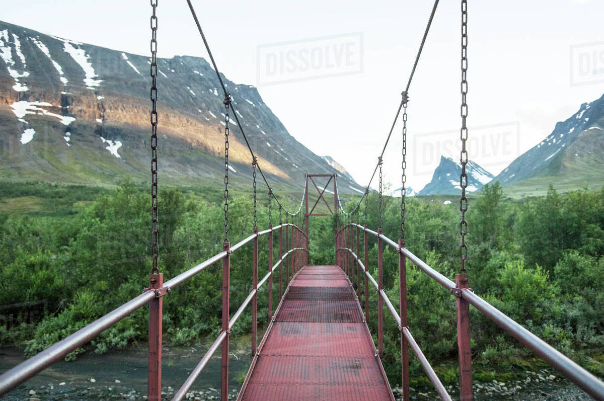 Hanging footbridge in mountains - Stock Photo - Dissolve