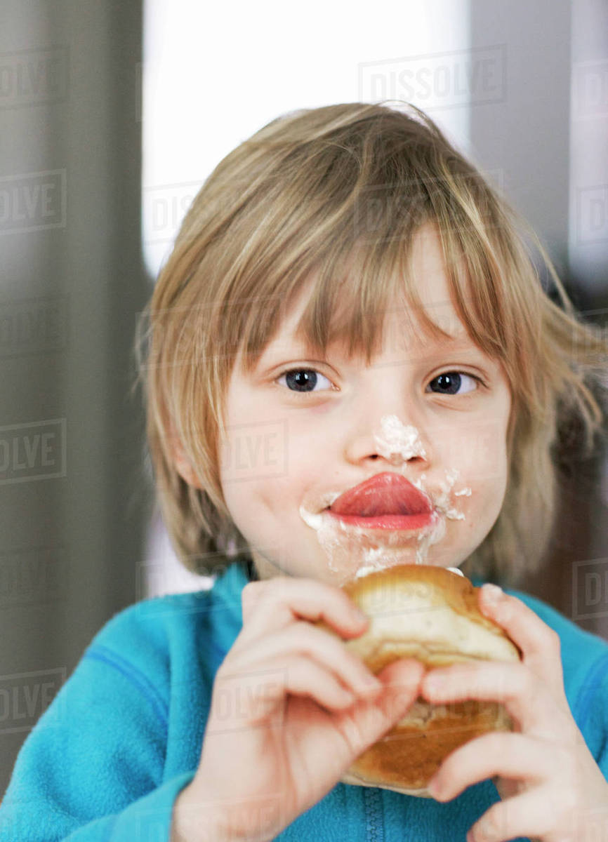 Boy eating bun - Royalty-free Stock Photo | Dissolve