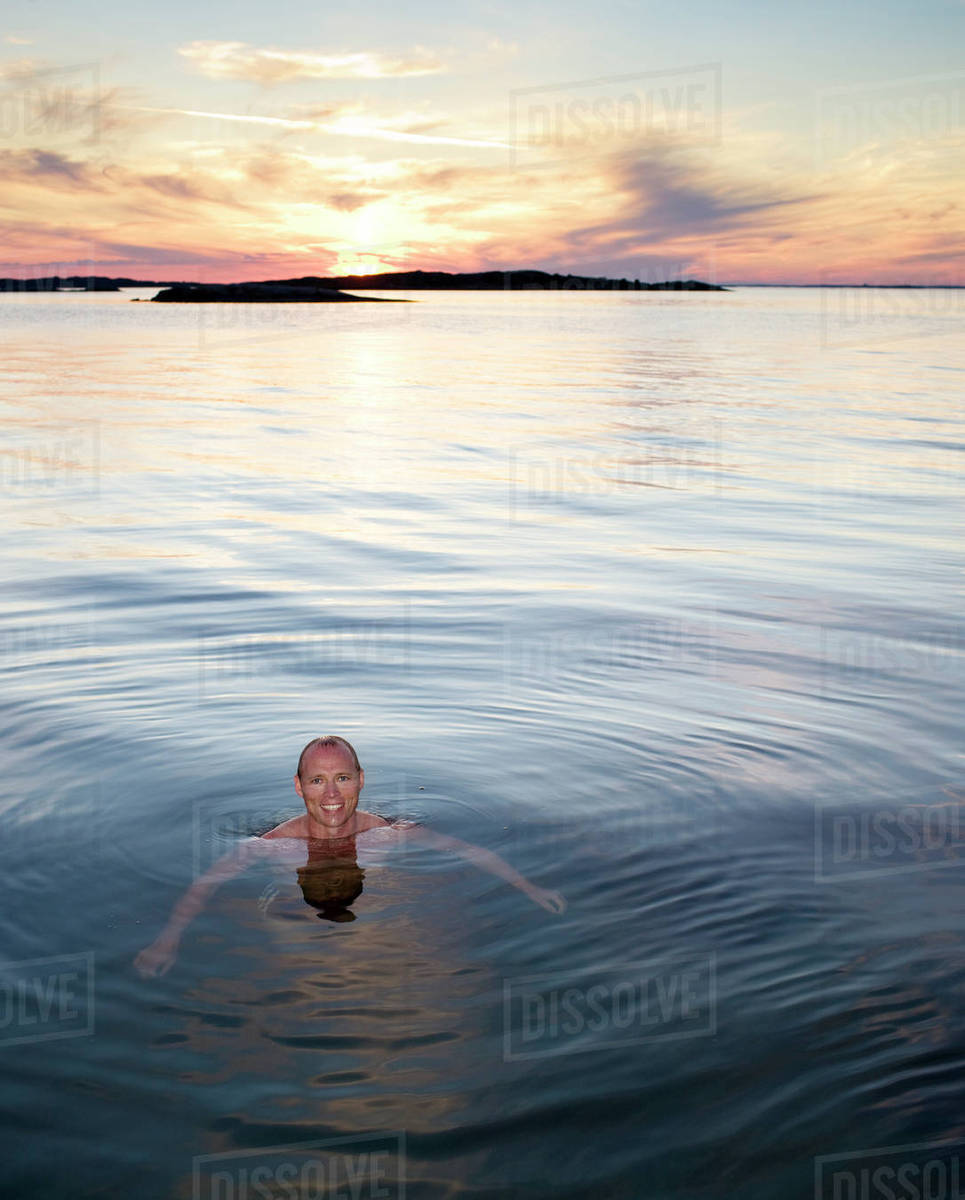 Man swimming at sunset - Stock Photo - Dissolve