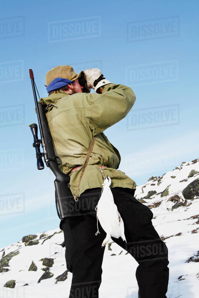 Hunter looking through binoculars - Royalty-free Stock Photo | Dissolve