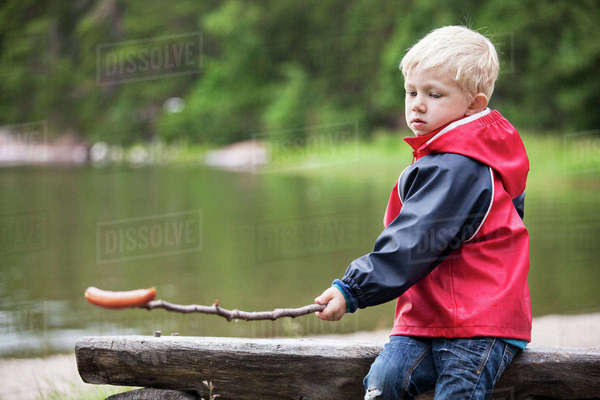 Boy with sausage on stick - Stock Photo - Dissolve