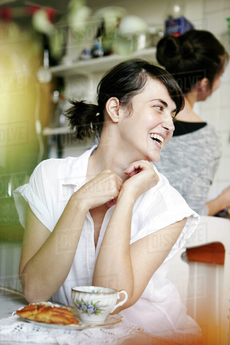 Happy young woman having tea - Royalty-free Stock Photo | Dissolve