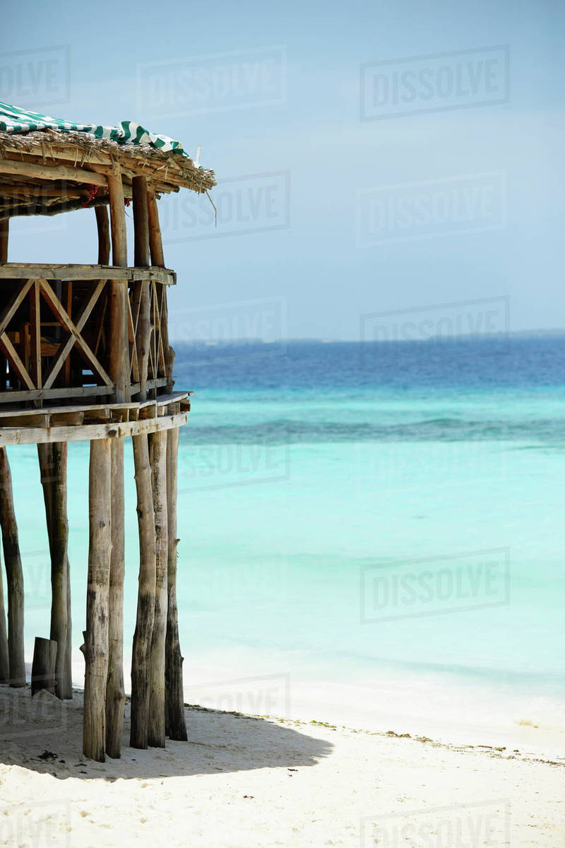 Wooden building on tropical beach - Stock Photo - Dissolve