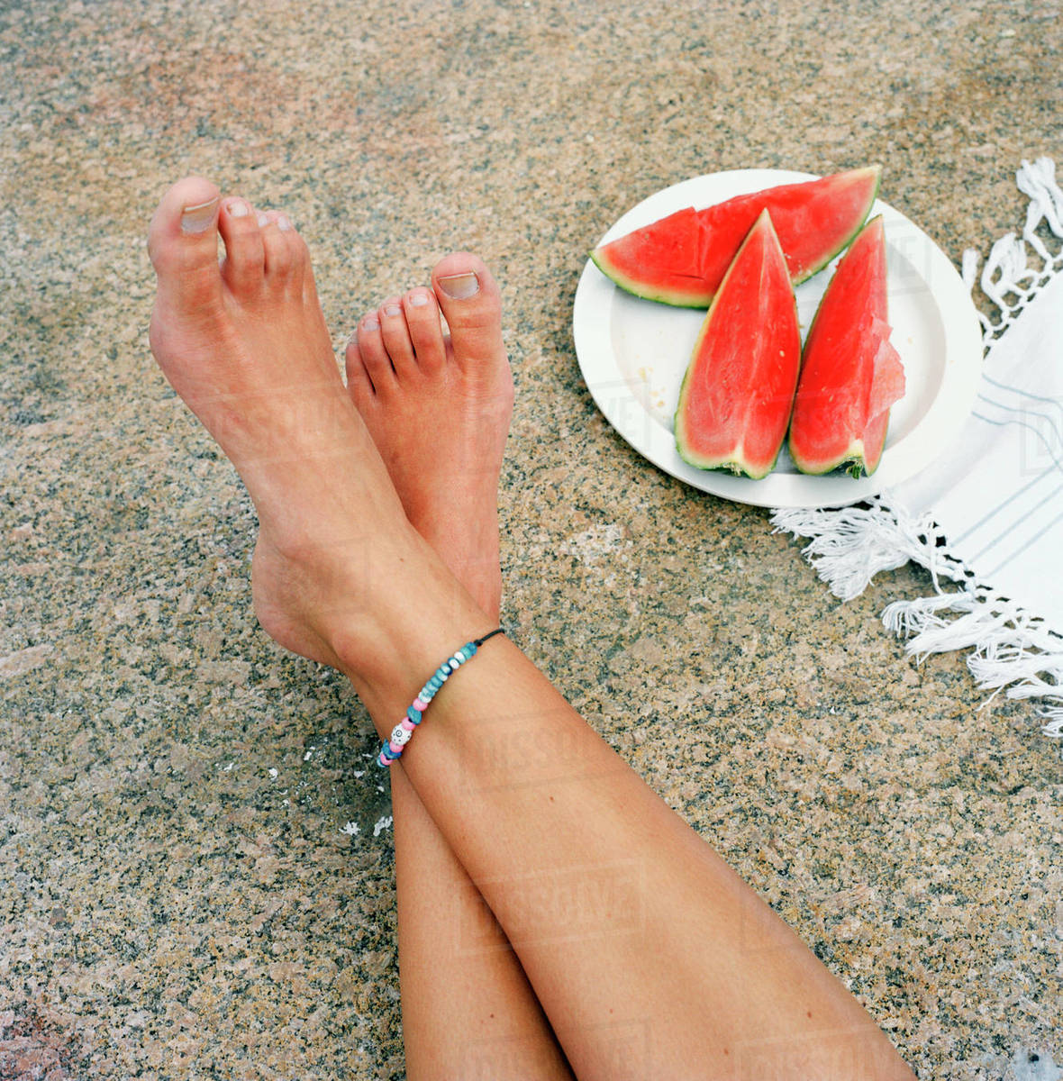 Womans feet on sand with watermelon on plate - Royalty-free Stock Photo ...