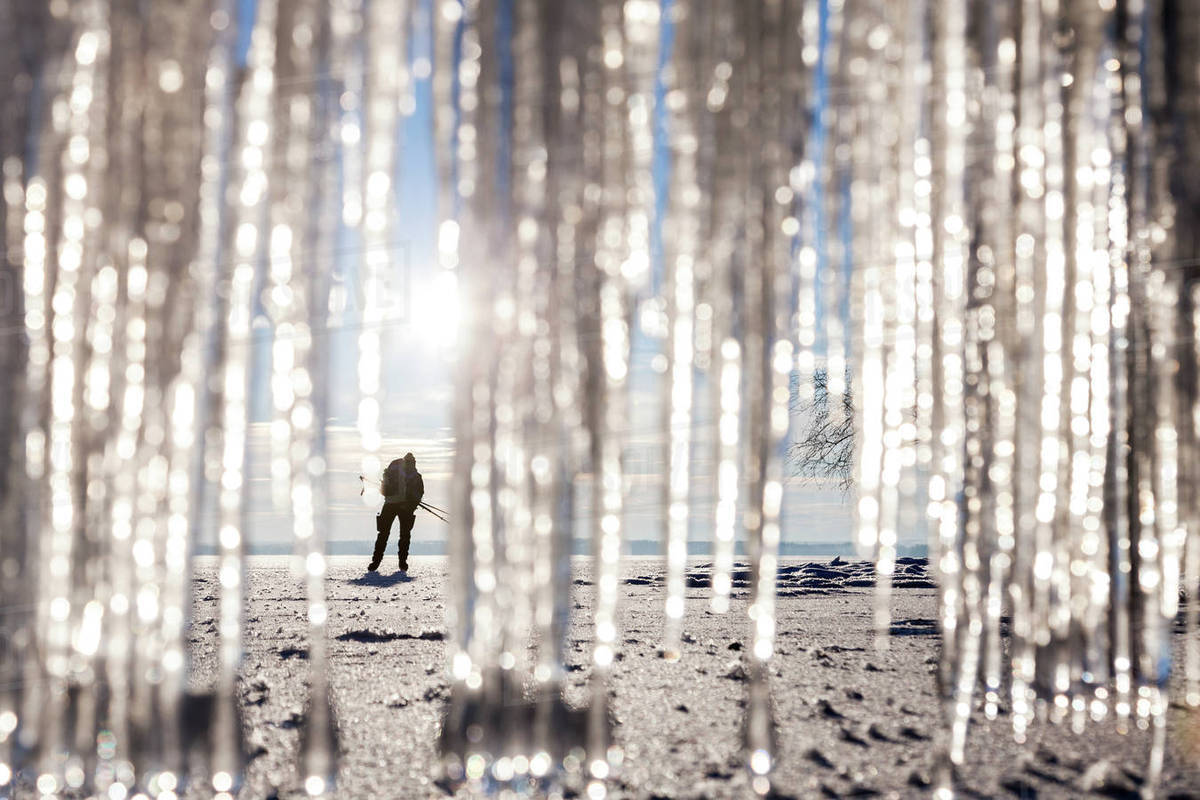 Silhouette of person on beach. icicles on foreground - Stock Photo ...
