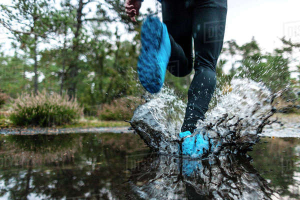 Person running through water - Stock Photo - Dissolve