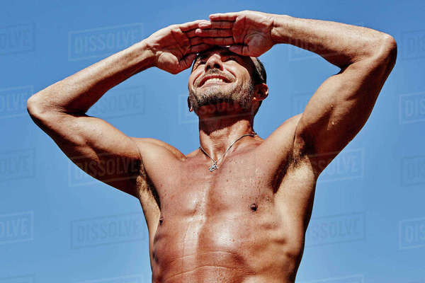 Muscular man shielding eyes - Royalty-free Stock Photo | Dissolve
