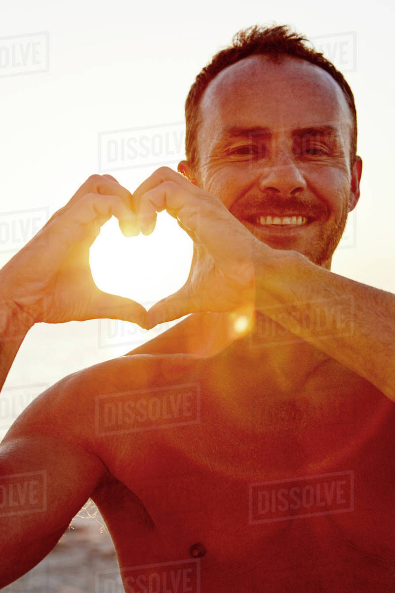 Man making heart shape with hands - Royalty-free Stock Photo | Dissolve