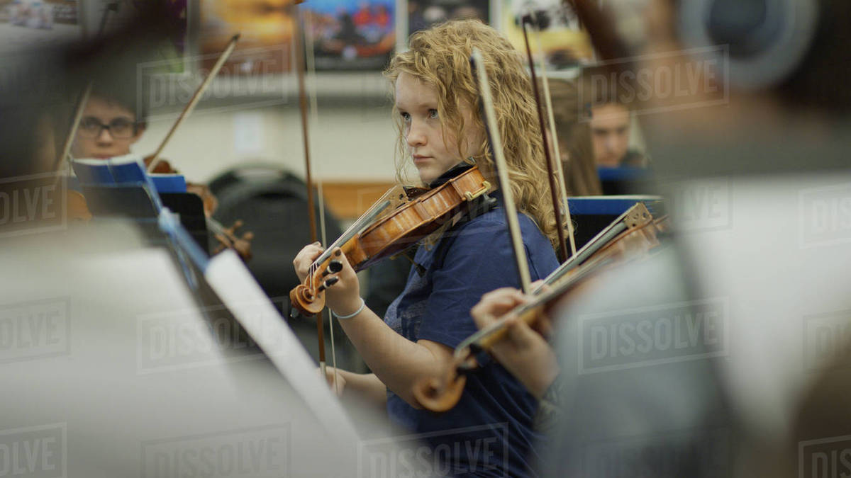 Selective focus view of serious teenage girl musician playing violin in ...