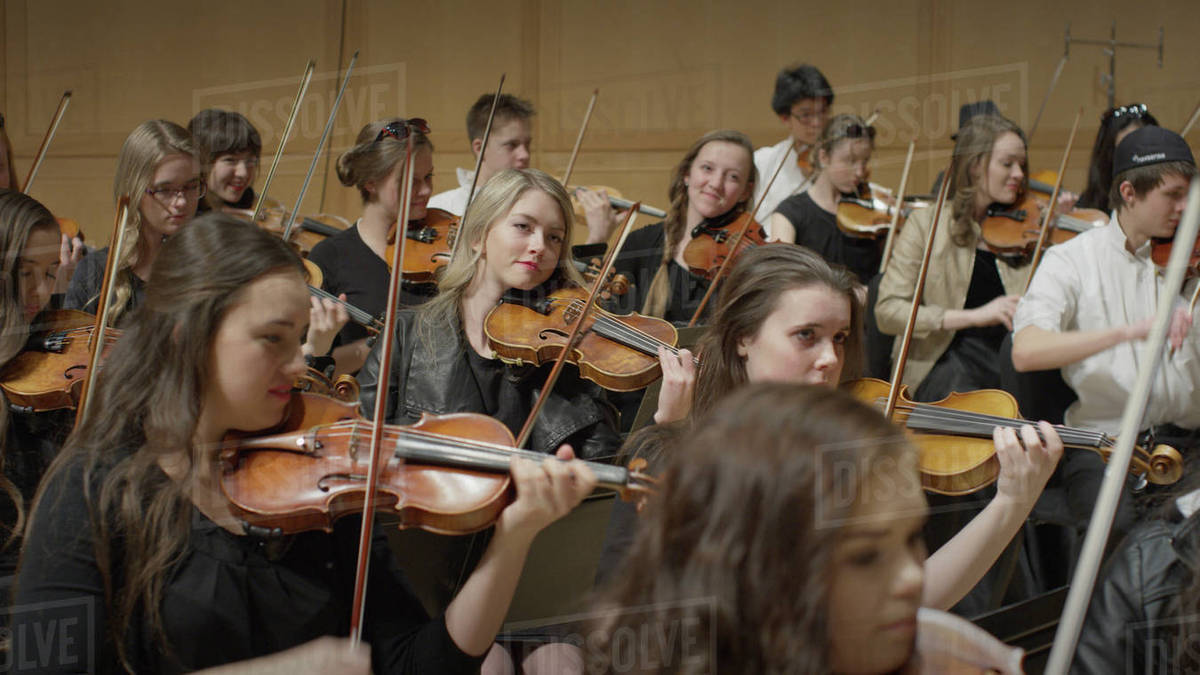 Selective focus view of student musicians playing instruments in ...