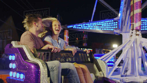 Blurred view of romantic boyfriend and girlfriend riding ride at ...