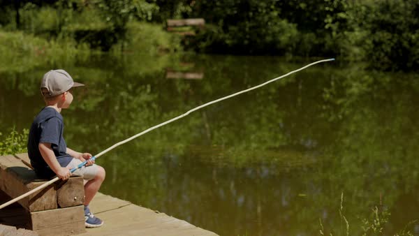Cute baby boy sitting on pier with fishing rod waiting catch enjoying ...