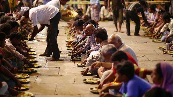 VARANASI, INDIA - MAY 2013: poor indian people eating free food at ...