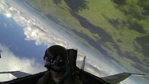 A pilot or passenger is shown flying in a F18 fighter plane, the clouds ...