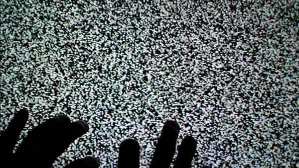 Male hands crawling up the TV screen with static television noise as ...