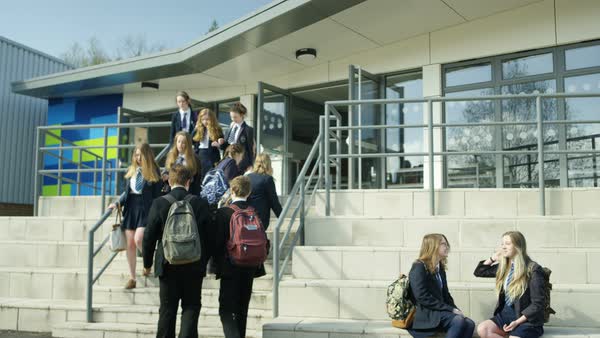 Young students walking into school building at the beginning of the day ...
