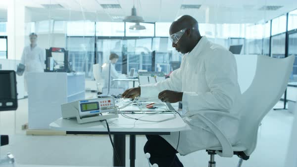 Electronics engineers working in modern lab building and testing ...