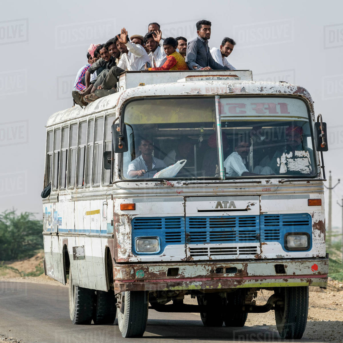 A bus full of people and passengers riding on the roof; Jaisalmer ...
