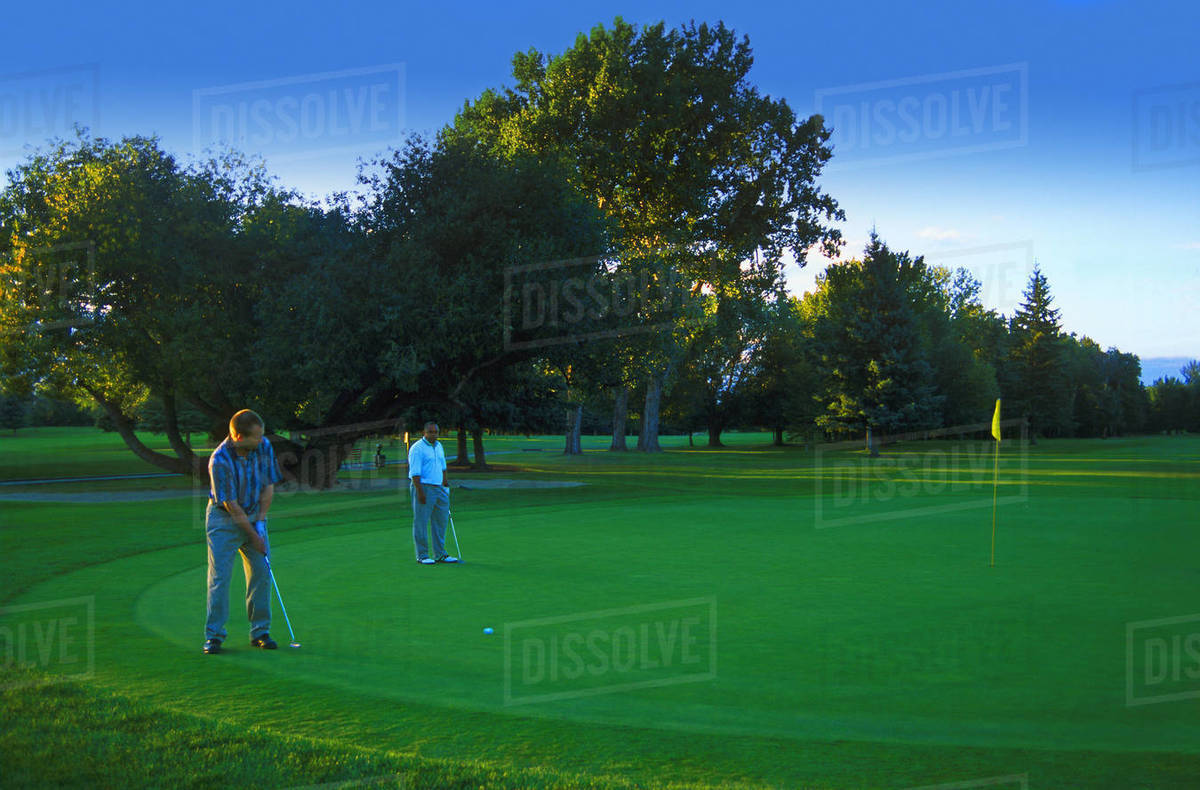 Two Golfers On Green - Stock Photo - Dissolve