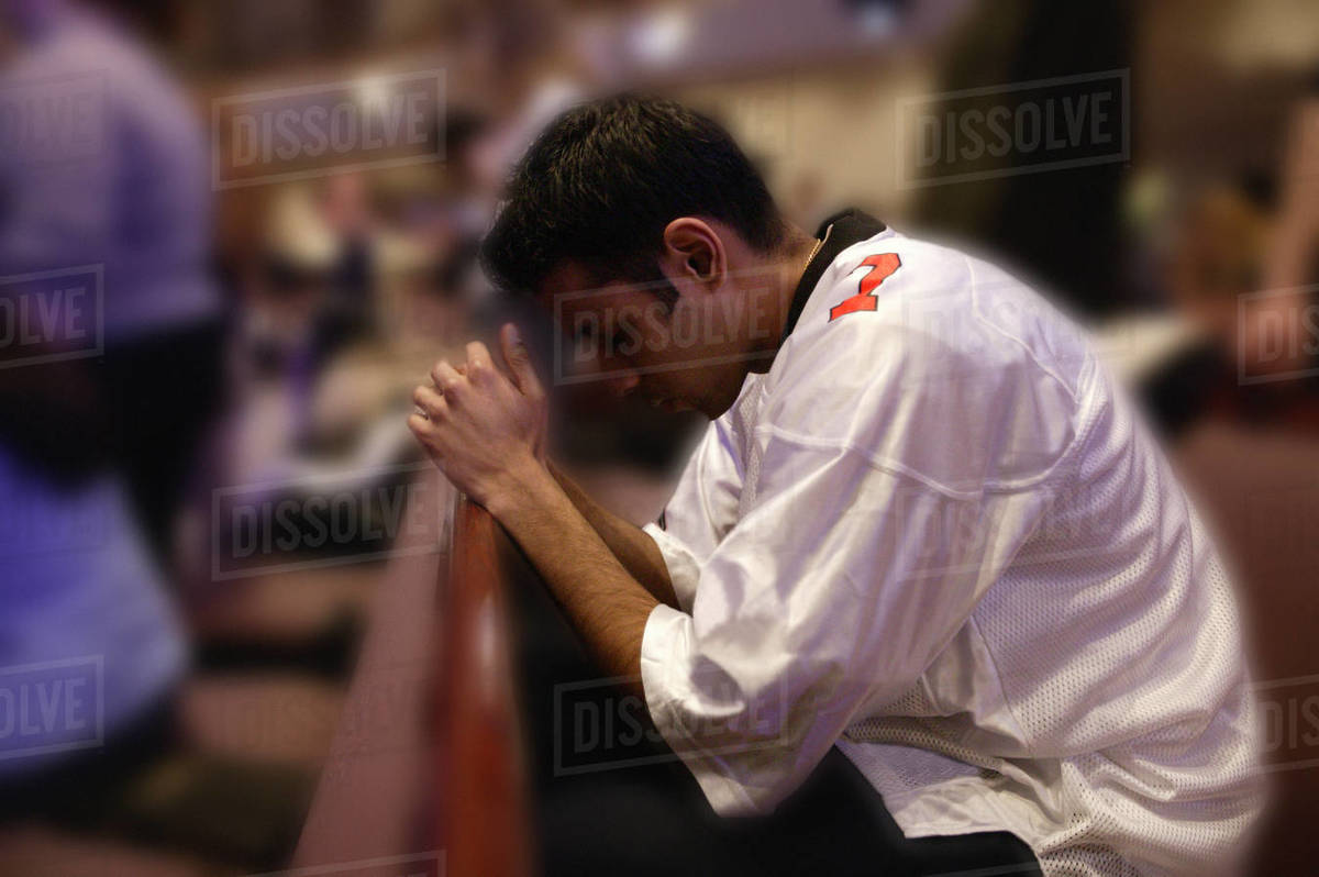 Young Man Praying In Church Pew - Royalty-free Stock Photo | Dissolve