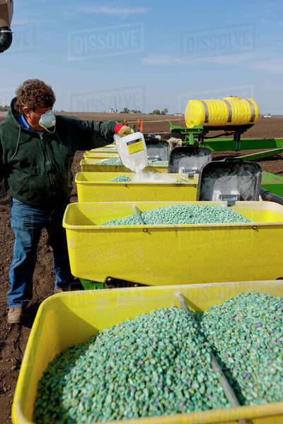 Agriculture - A farmer prepares for corn planting operations by adding ...