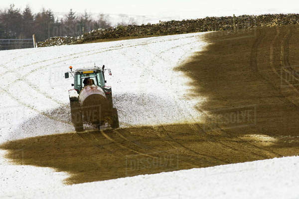 Agriculture - A tractor and slurry wagon spreading animal manure slurry ...
