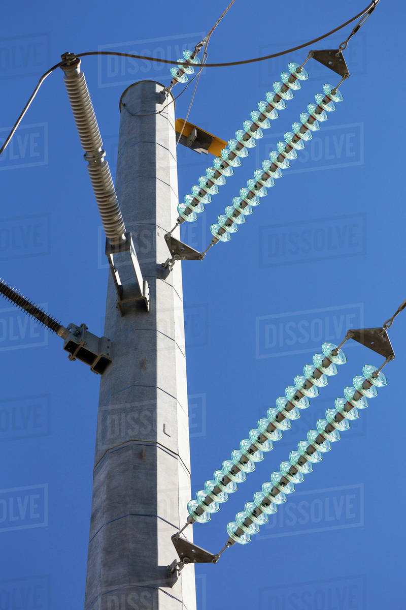 Low angle view of large metal hydro tower with glass insulators and ...