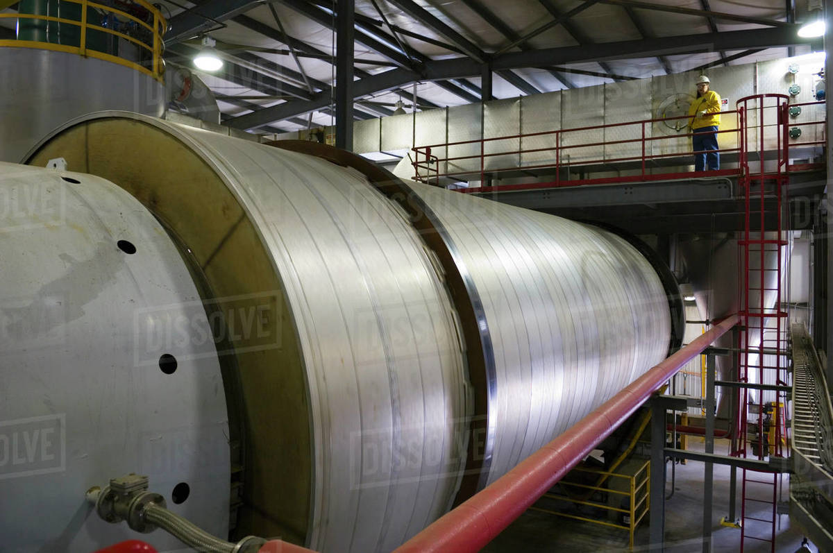 Agriculture - Ethanol production plant. Technician above large rotary ...