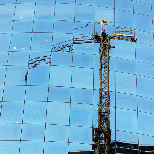 A crane reflected in the glass window facade of a building; Santiago ...
