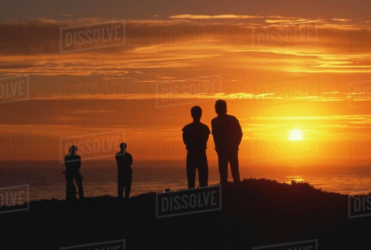Silhouetted Figures In Sunset - Stock Photo - Dissolve