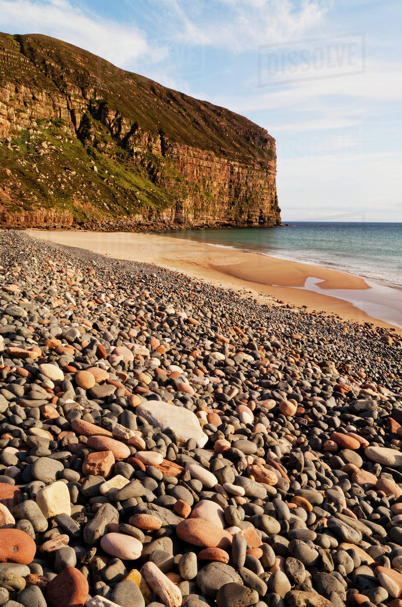 Pebble beach and cliffs along the coast, Rackwick; Orkney, Scotland ...