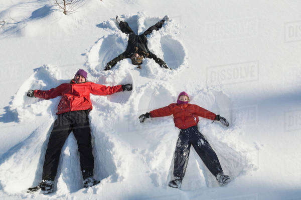 A family making snow angels in wintertime; Talkeetna, Alaska, United ...